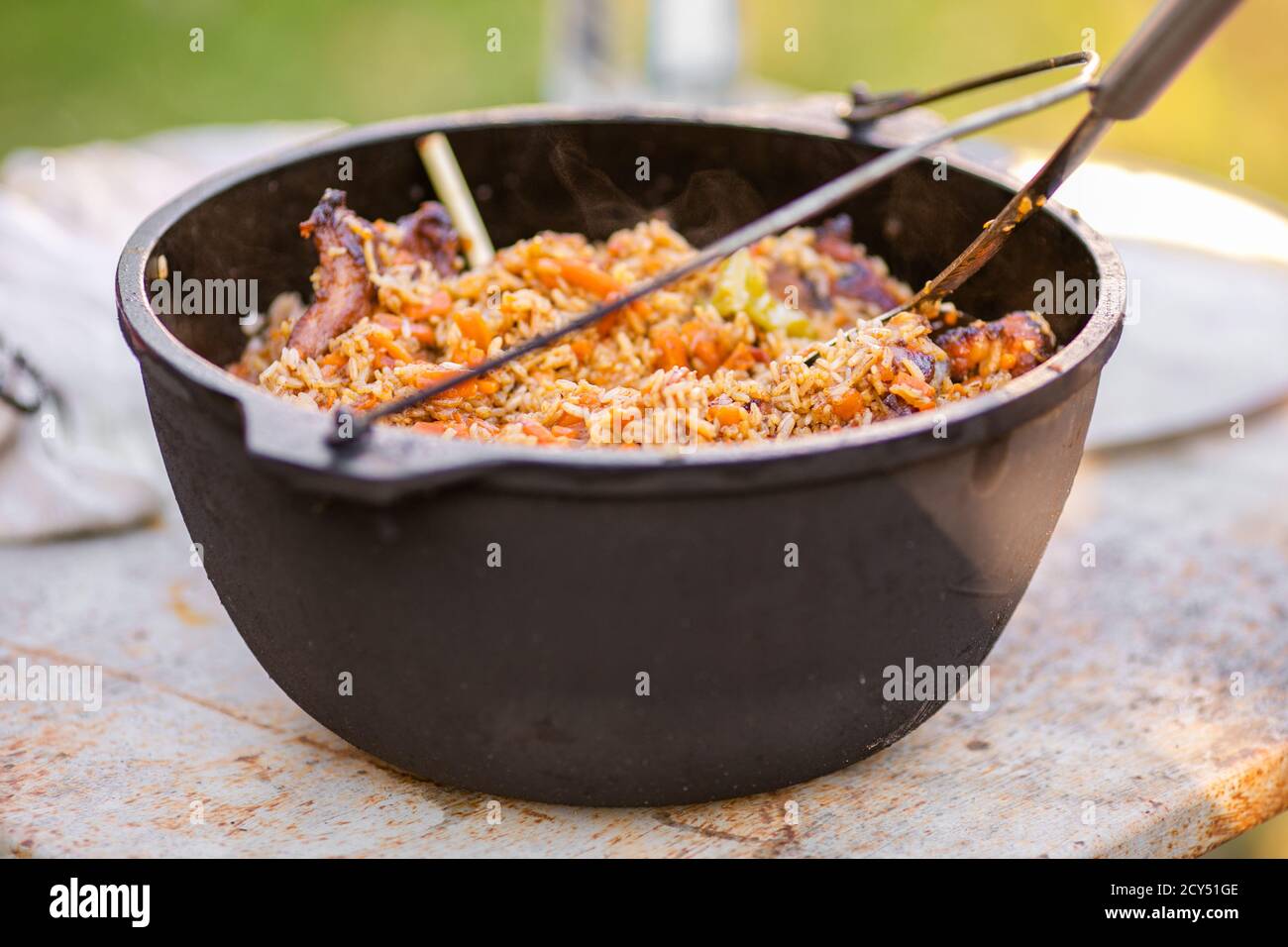 Preparation of raditional armenian pilaf in a cauldron on an open fire ...