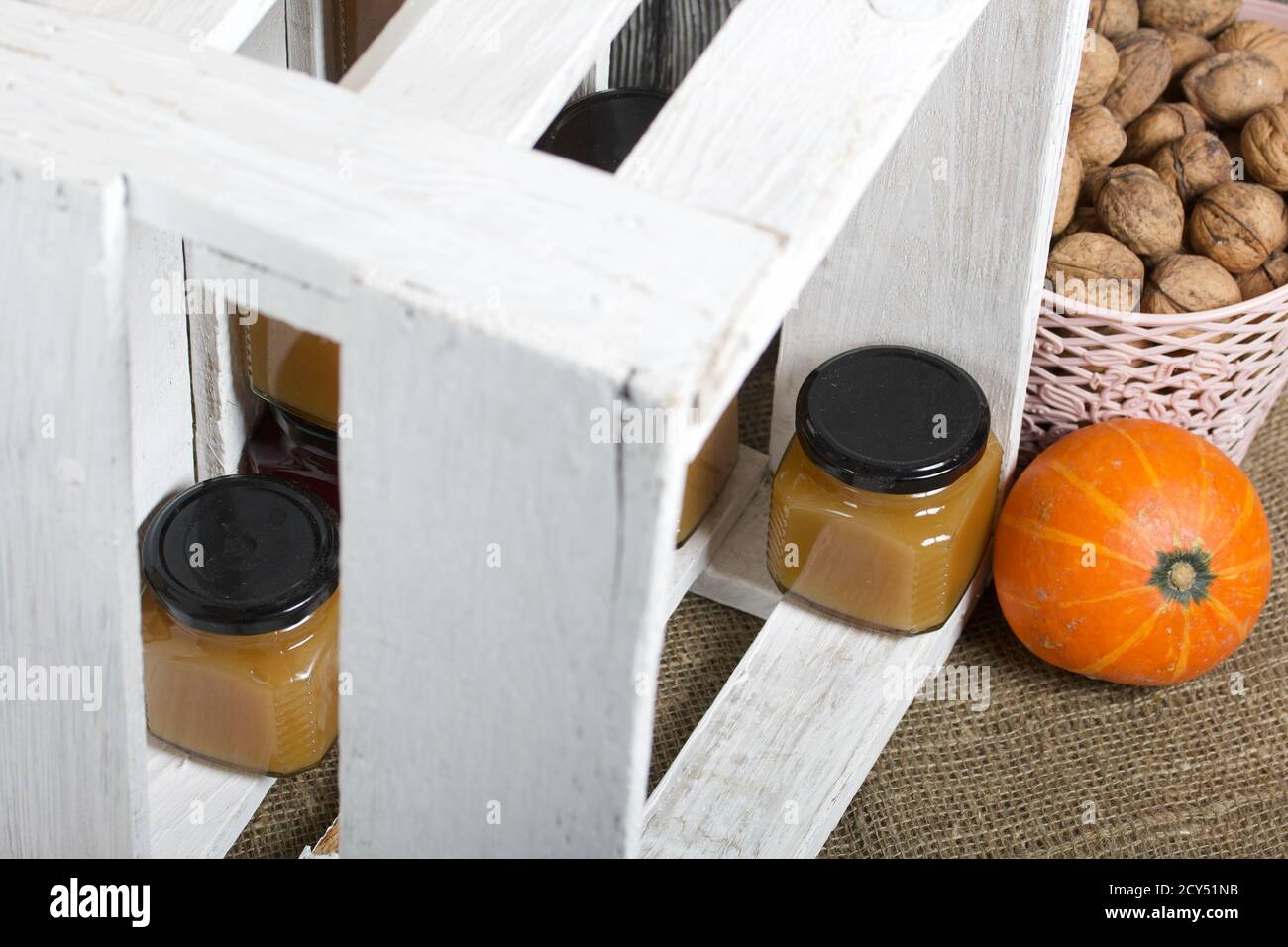 Fruit jam in jars. Stands in a wooden box painted white. Next to it is ...