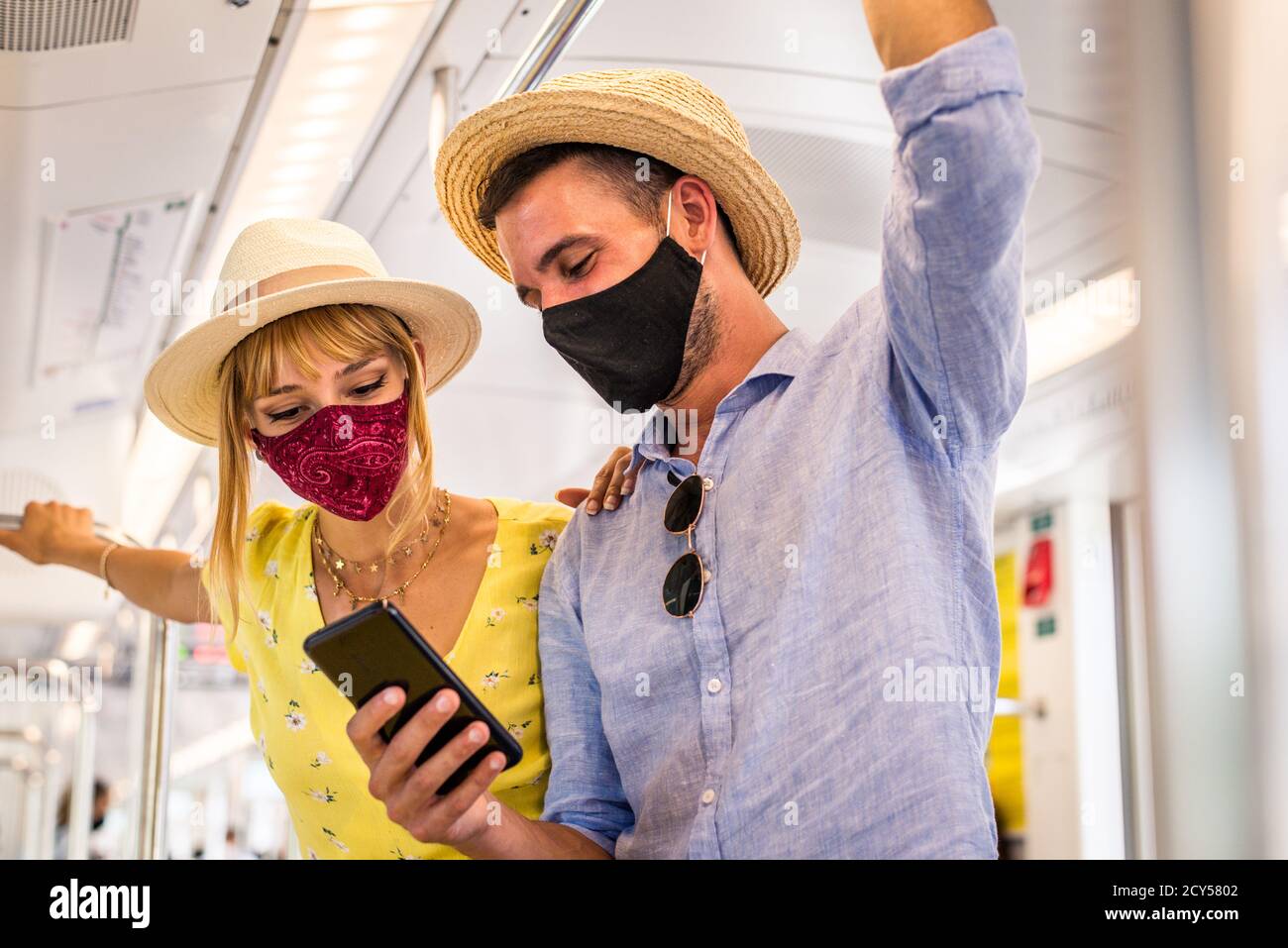 Beautiful couple wearing protective face masks and kissing during covid ...