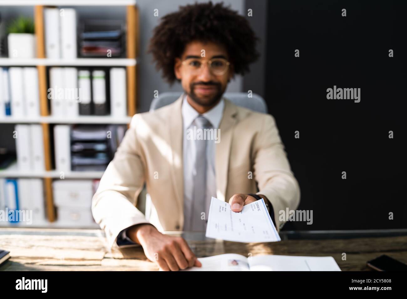 African Giving Cheque. Hand Holding Insurance Check Stock Photo - Alamy