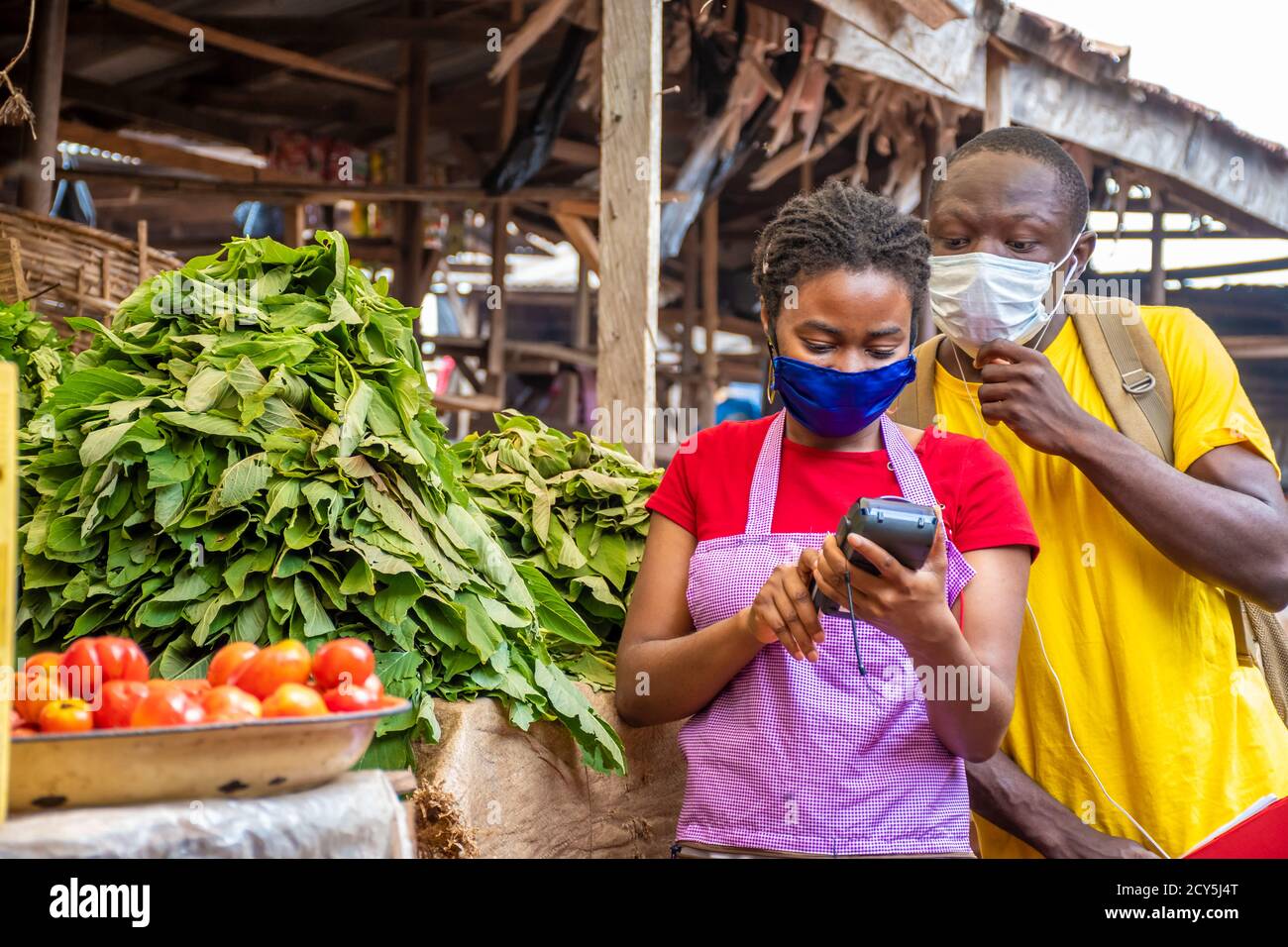 young black man spying on a lady using a pos machine Stock Photo - Alamy