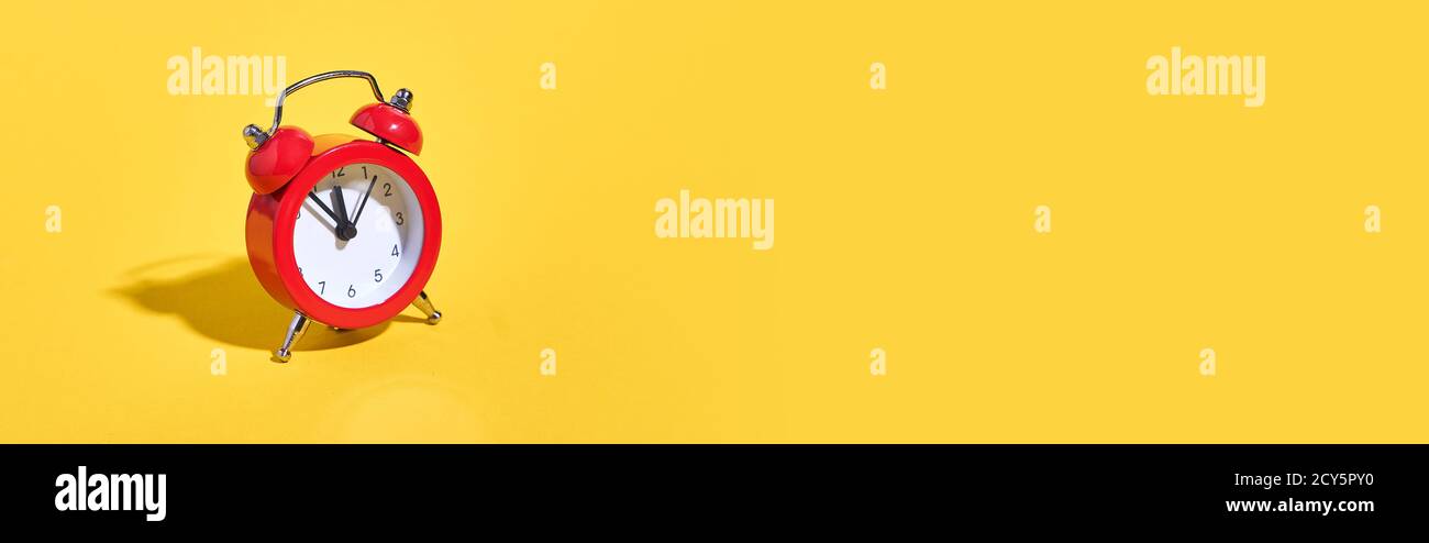 Red retro alarm clock on yellow background. Minimal time concept ...