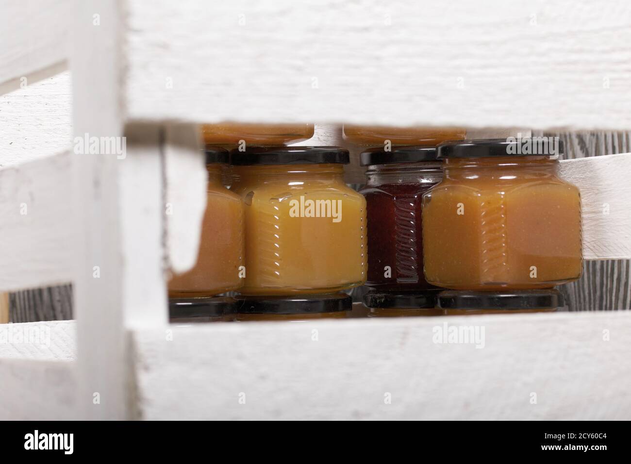 Fruit jam in jars. Stands in a wooden box painted white Stock Photo - Alamy