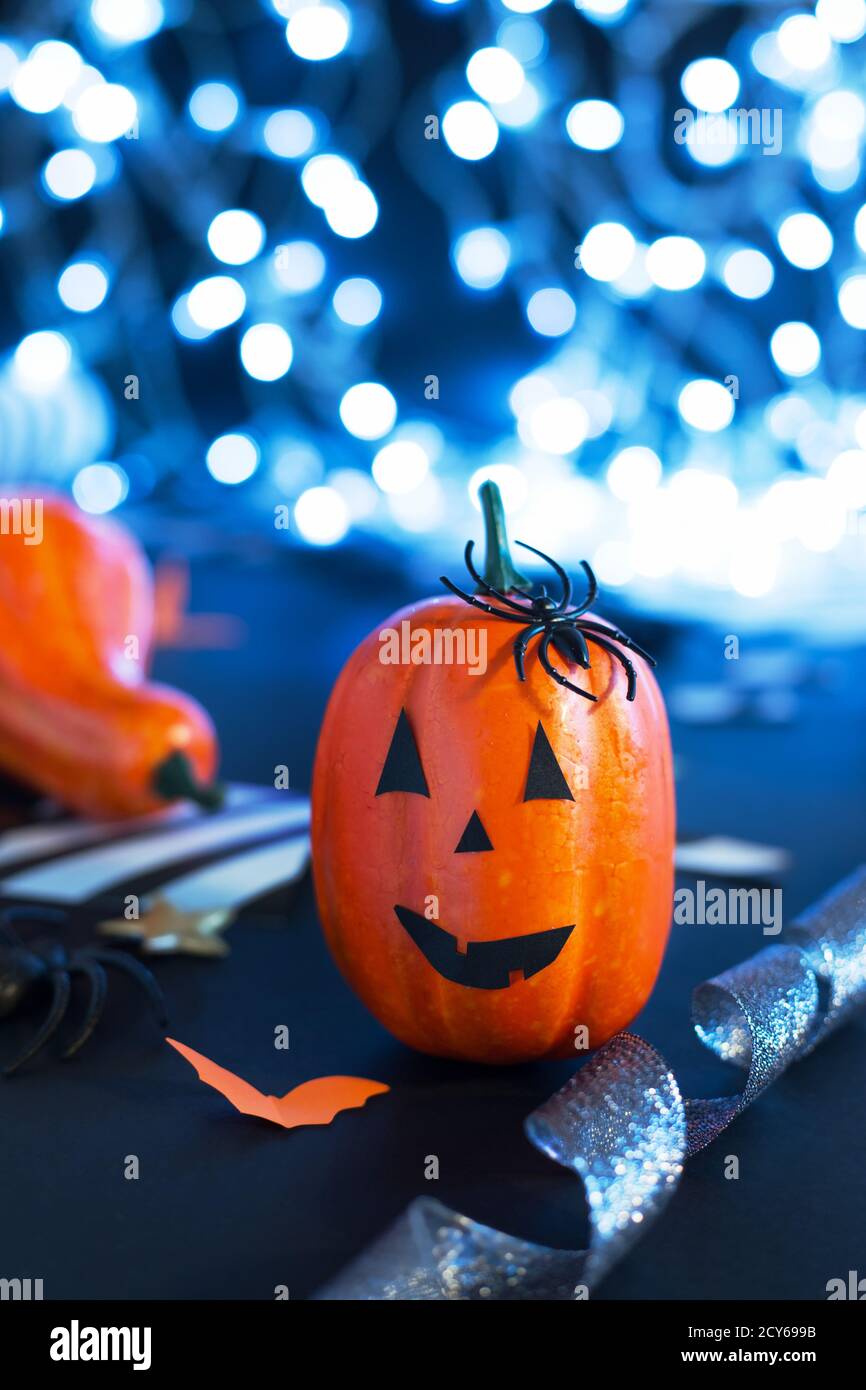 jack-o'-lantern with spider, paper bats, pumpkin ribbons, confetti on ...