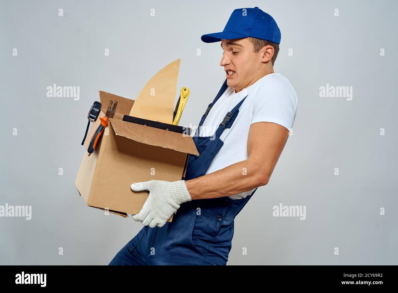 man in working uniform with a box in his hands tools loader delivery ...