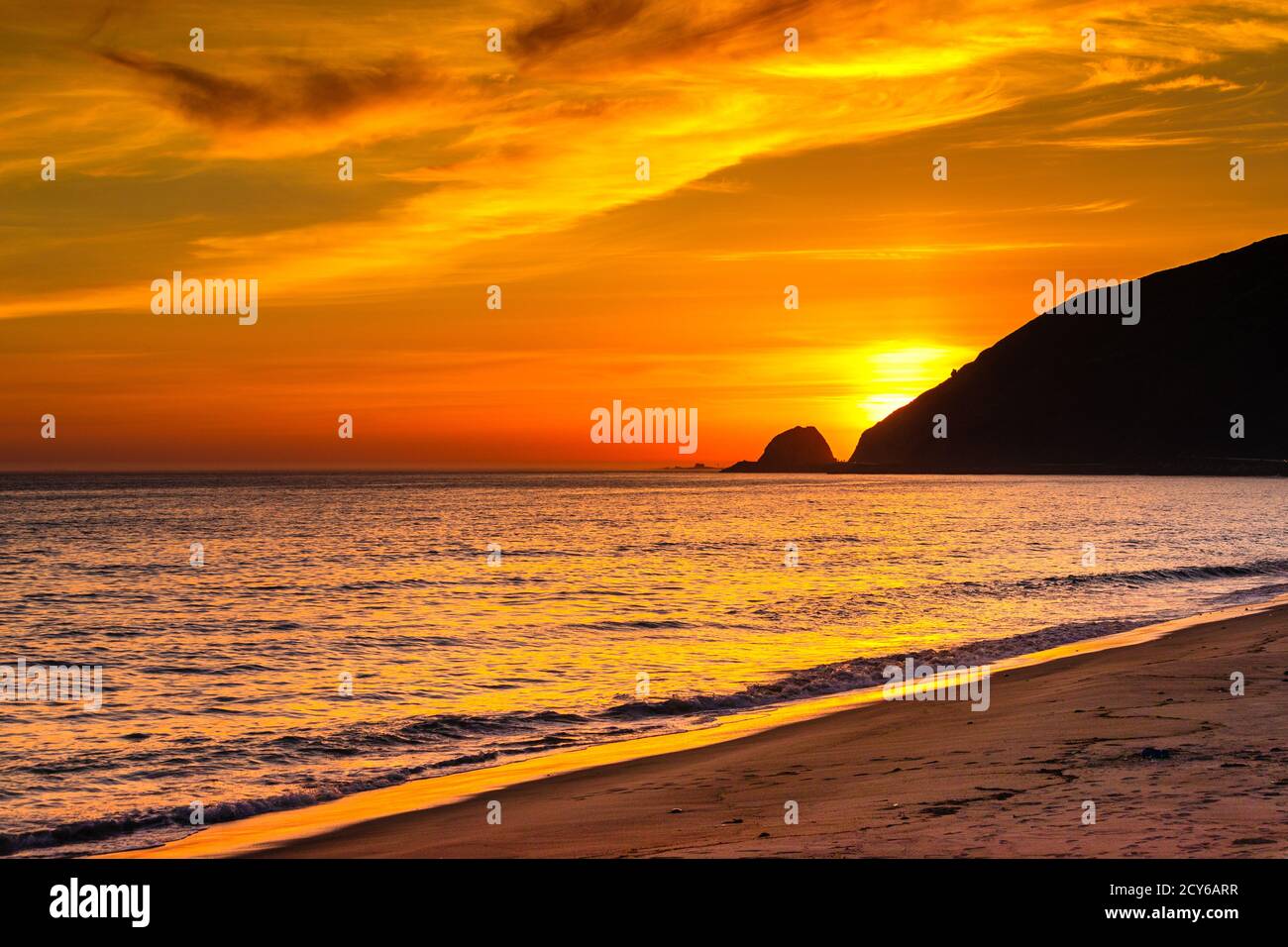 Orange sunset on a calm beach Stock Photo - Alamy