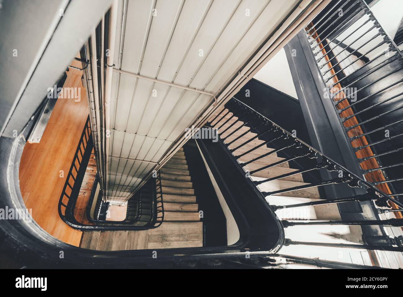 Wide-angle view from above of a long stairwell going down in a spiral ...