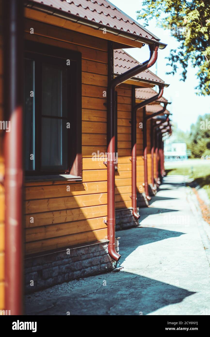 A vertical shot of a row of yellow equal regular wooden single-story ...