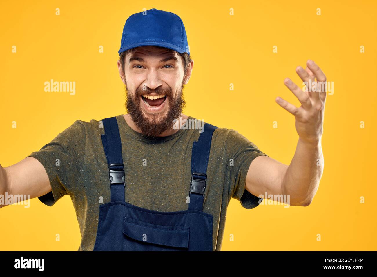 Worker man in uniform worker service yellow background emotion Stock ...