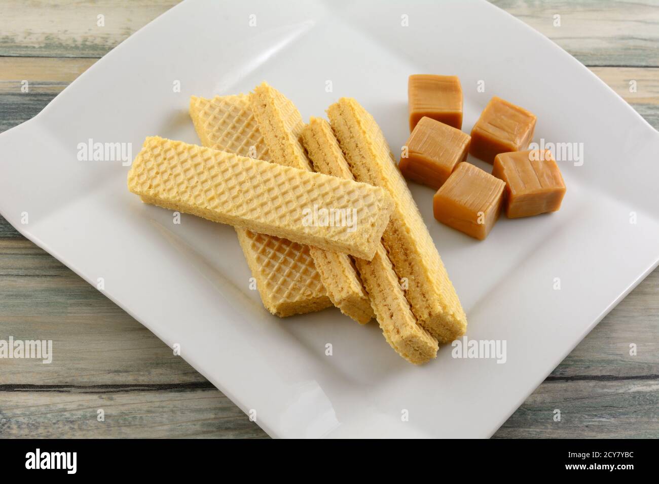 Caramel wafer cookies with caramel candy squares on white dessert plate ...