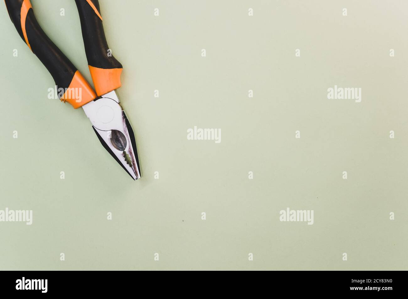 Top view of pliers isolated on a green background Stock Photo - Alamy