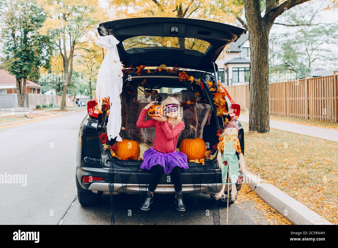Trick or trunk. Child girl celebrating Halloween in trunk of car. Kid ...