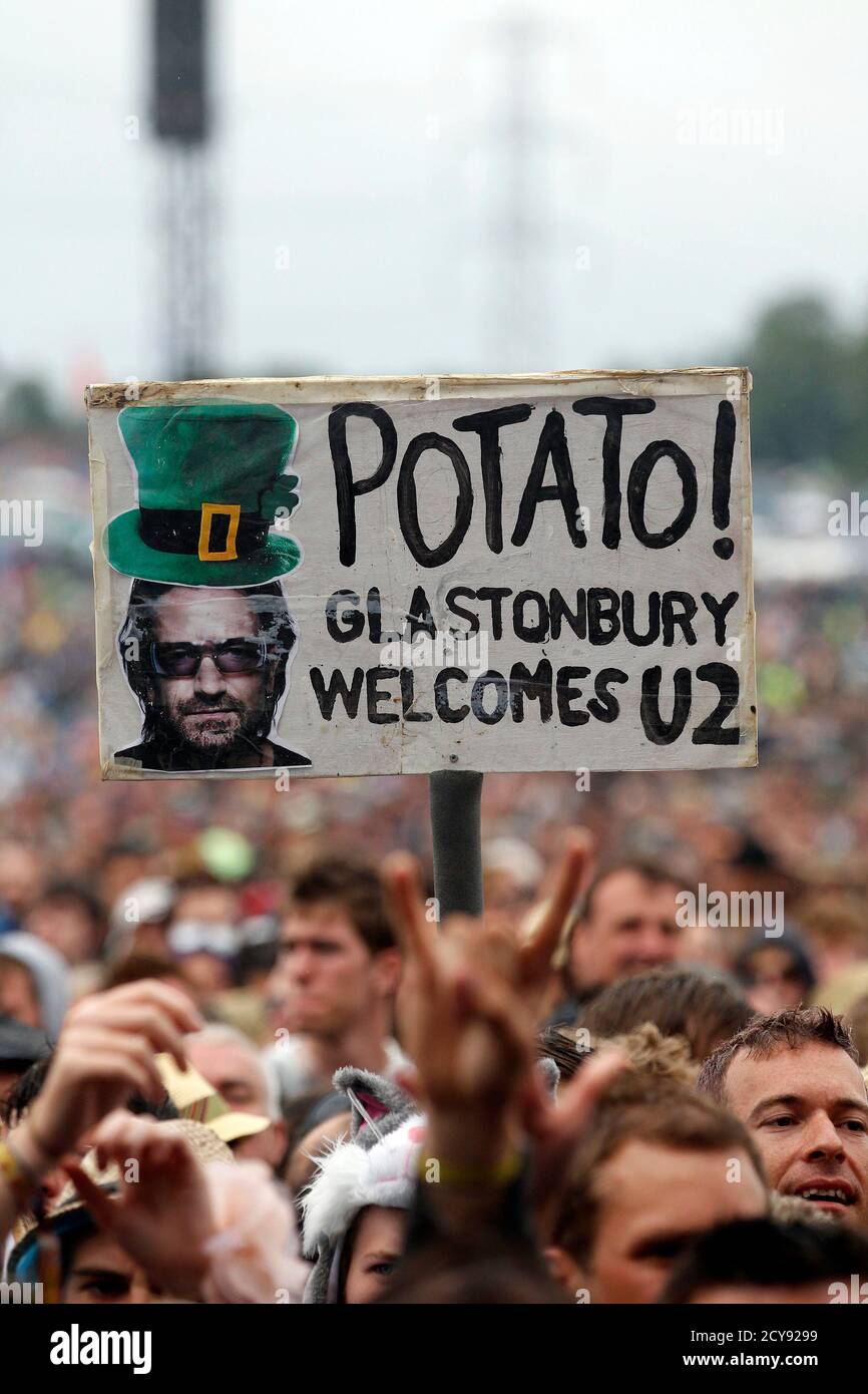 A Festival Goer Holds A Placard Protesting Against Irish Group U2 Who