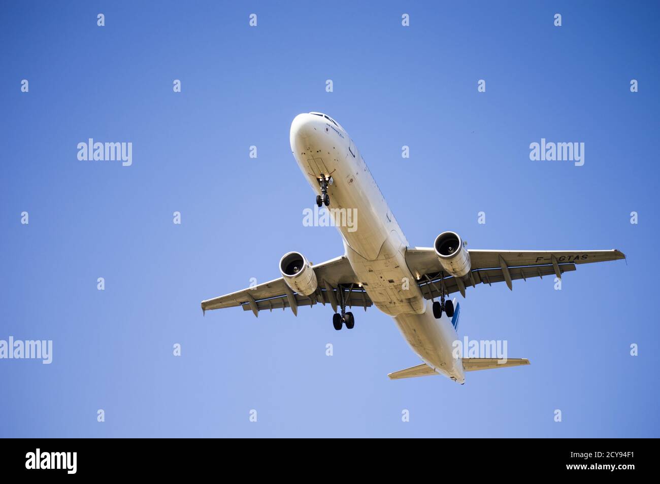 Low angle shot of a plane flying under blue sky Stock Photo - Alamy