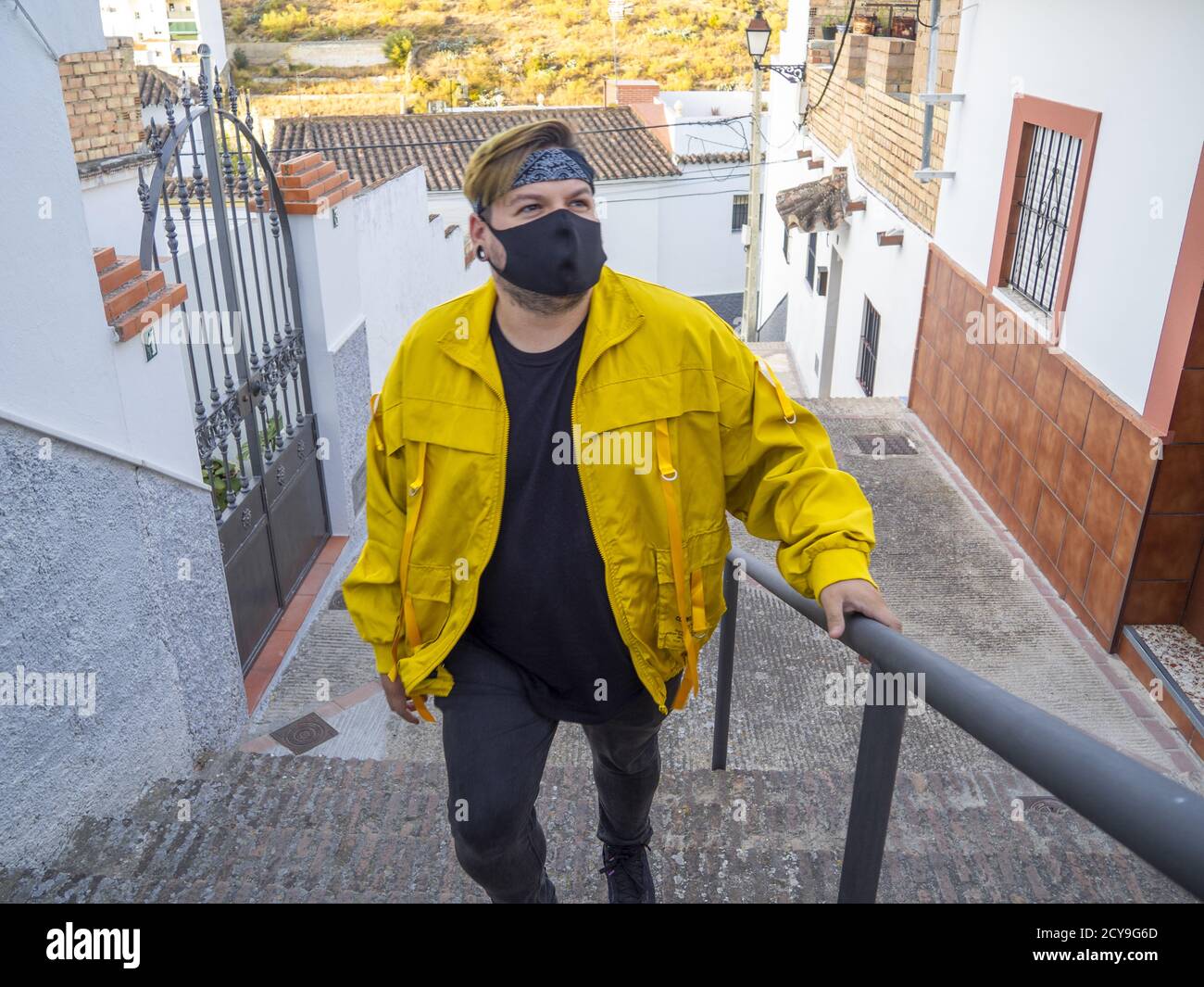 Man wearing a facemask while climbing the stairs Stock Photo - Alamy