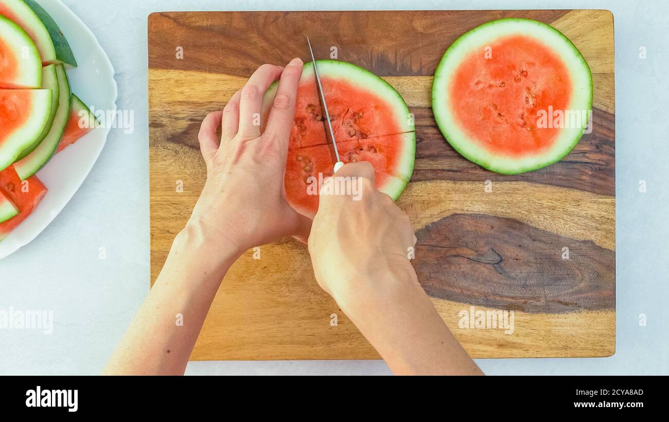 Chef slicing watermelon on wooden cutting board Stock Photo - Alamy