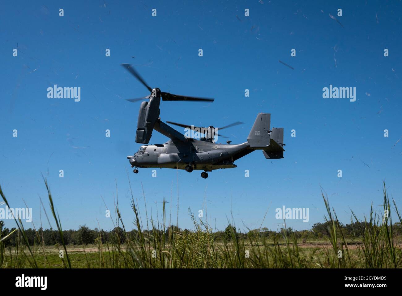 A CV-22B Osprey tiltrotor aircraft prepares to land in a field at ...