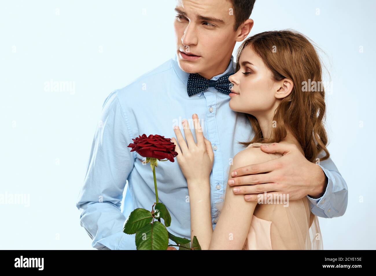 Man and woman with a red rose on a light background love family hugs ...