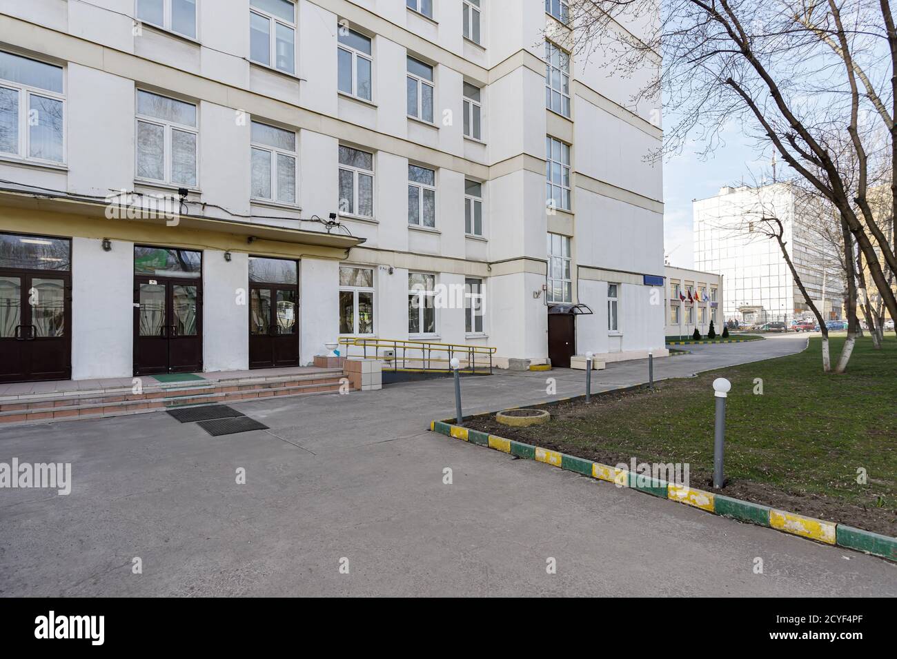 School building with an empty courtyard. Classic light plastered school ...