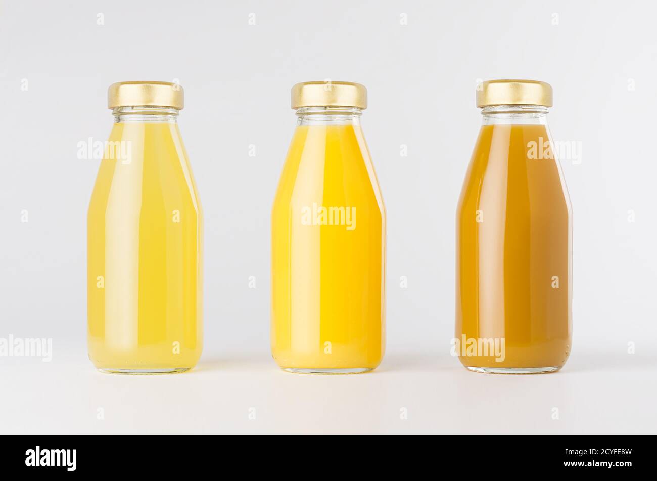 Orange, yellow fruit juices collection in glass bottles with cap in row ...