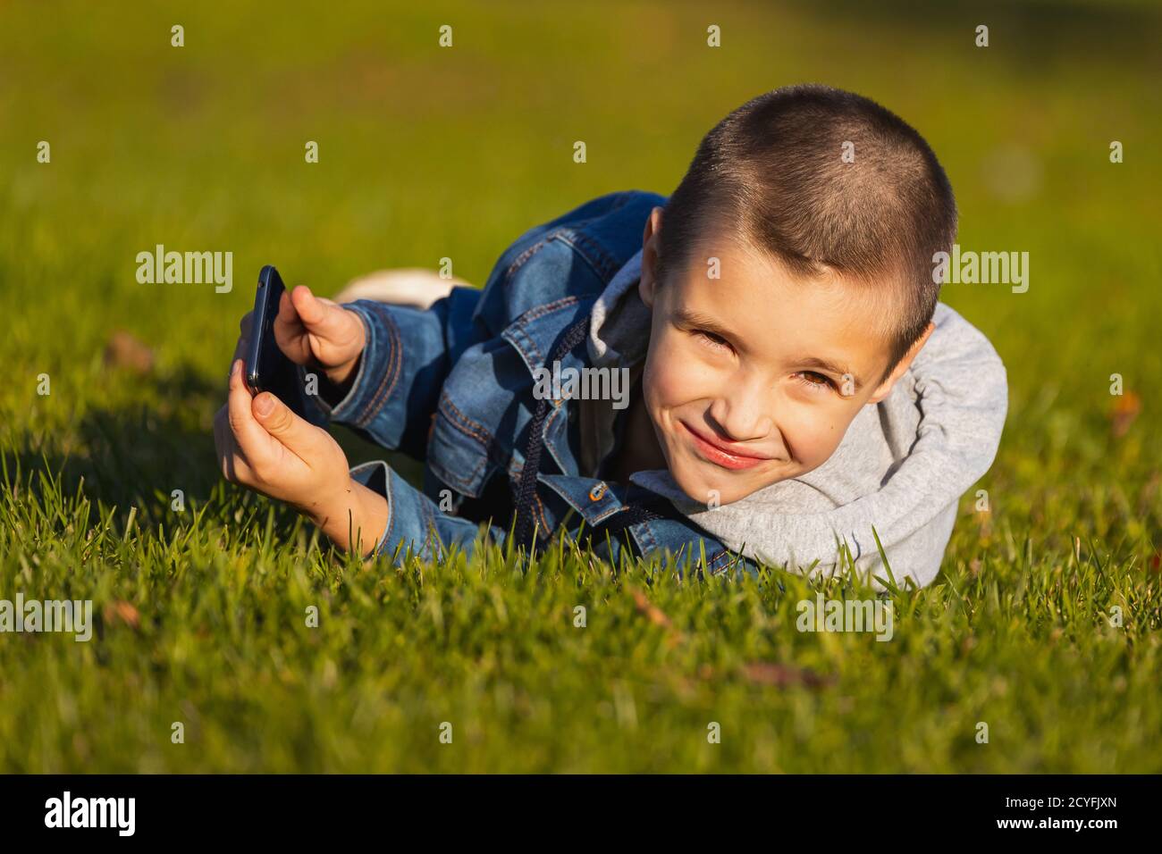 Little boy child playing mobile games on smartphone in the park. Funny ...