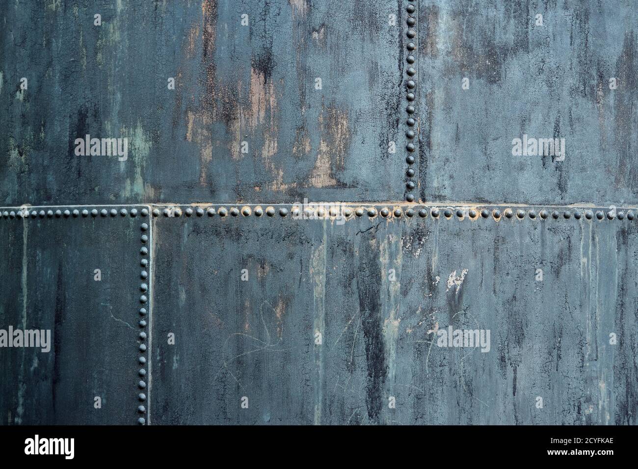 Part of an old storage container made of riveted iron plates, used and ...