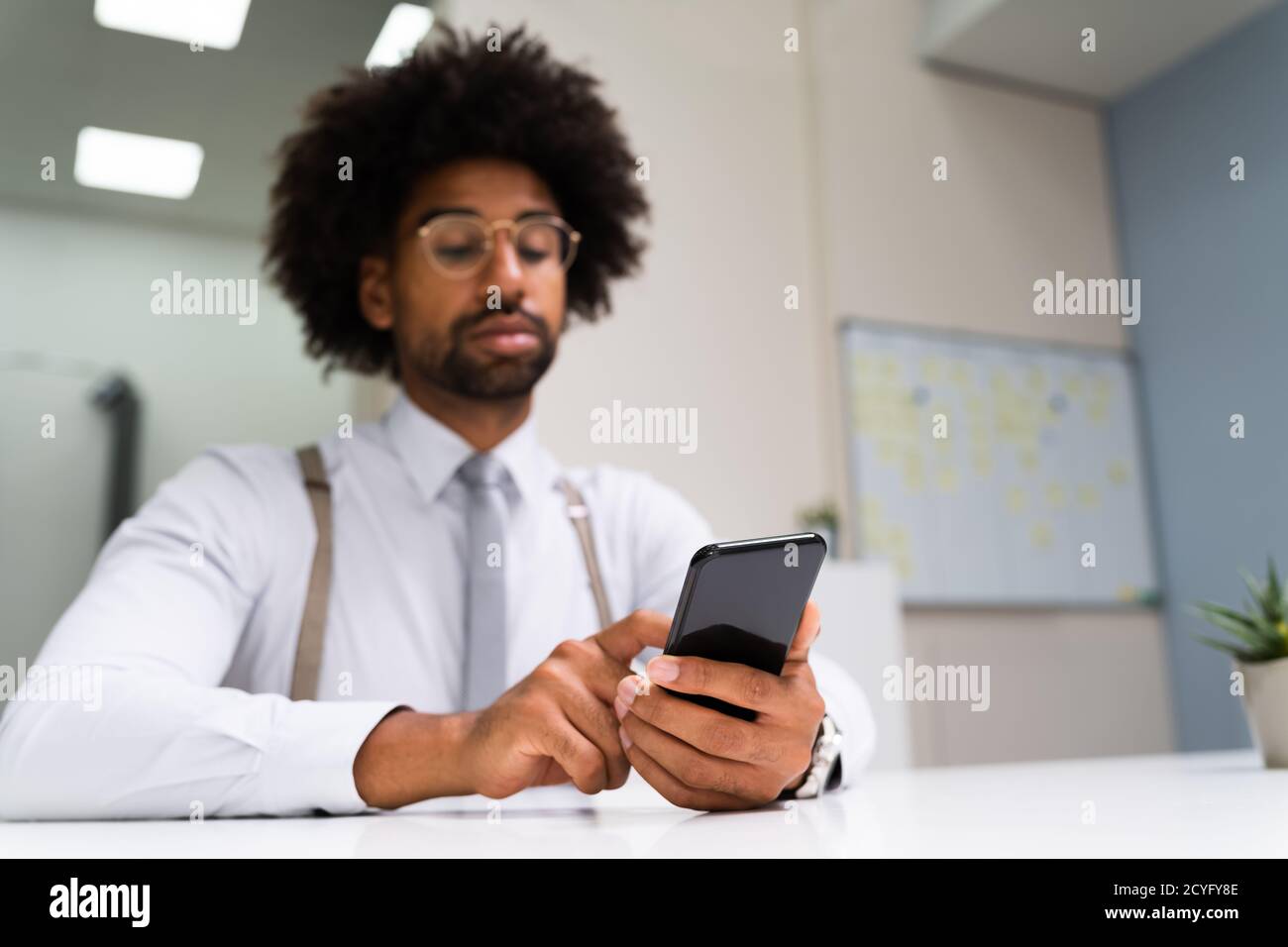 African Man Holding Smartphone Or Mobile Phone Stock Photo - Alamy