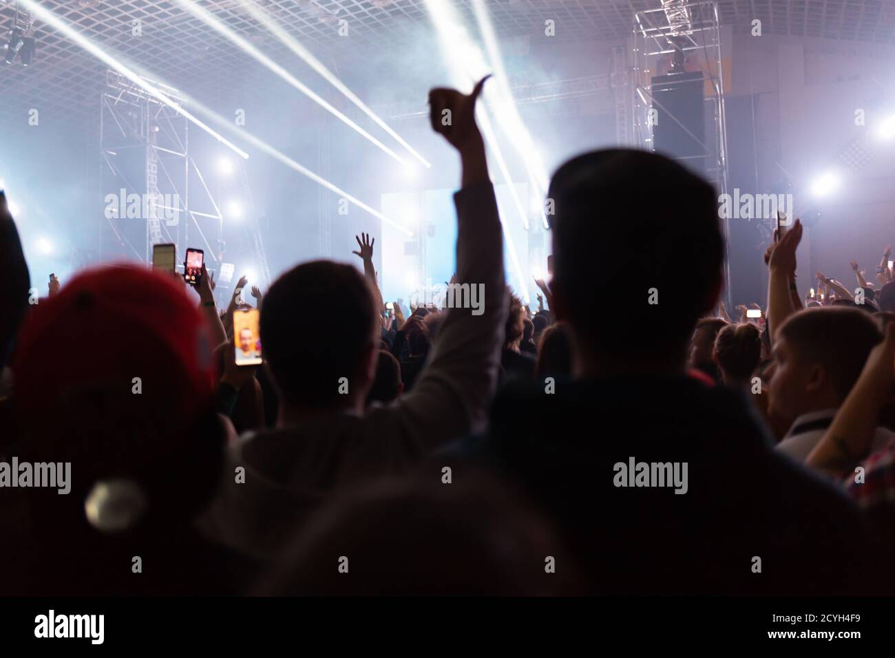 A crowd of people at the concert have fun and dance to the music at the ...