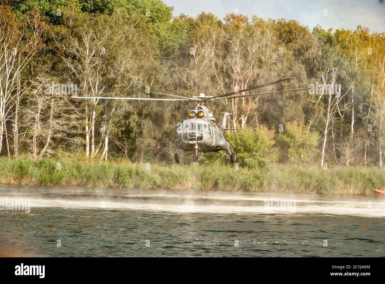 Military Mi-8 helicopter over the water. You can see the water breeze ...