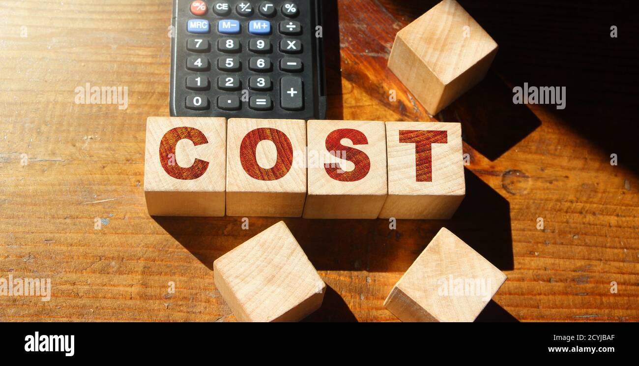 Wooden cubes foorming word COST and calculator. business financial ...
