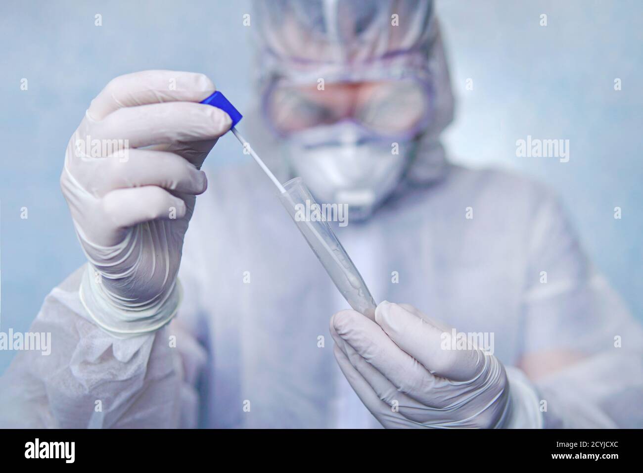 Examination of mucosal smears. The scientist is holding a test tube ...