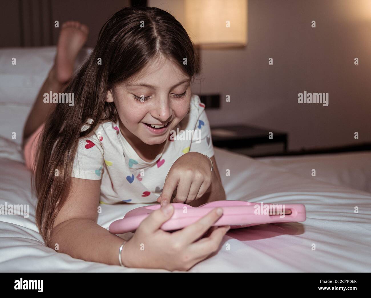 Caucasian Girl with brown hair and green eyes playing with her iPad at ...