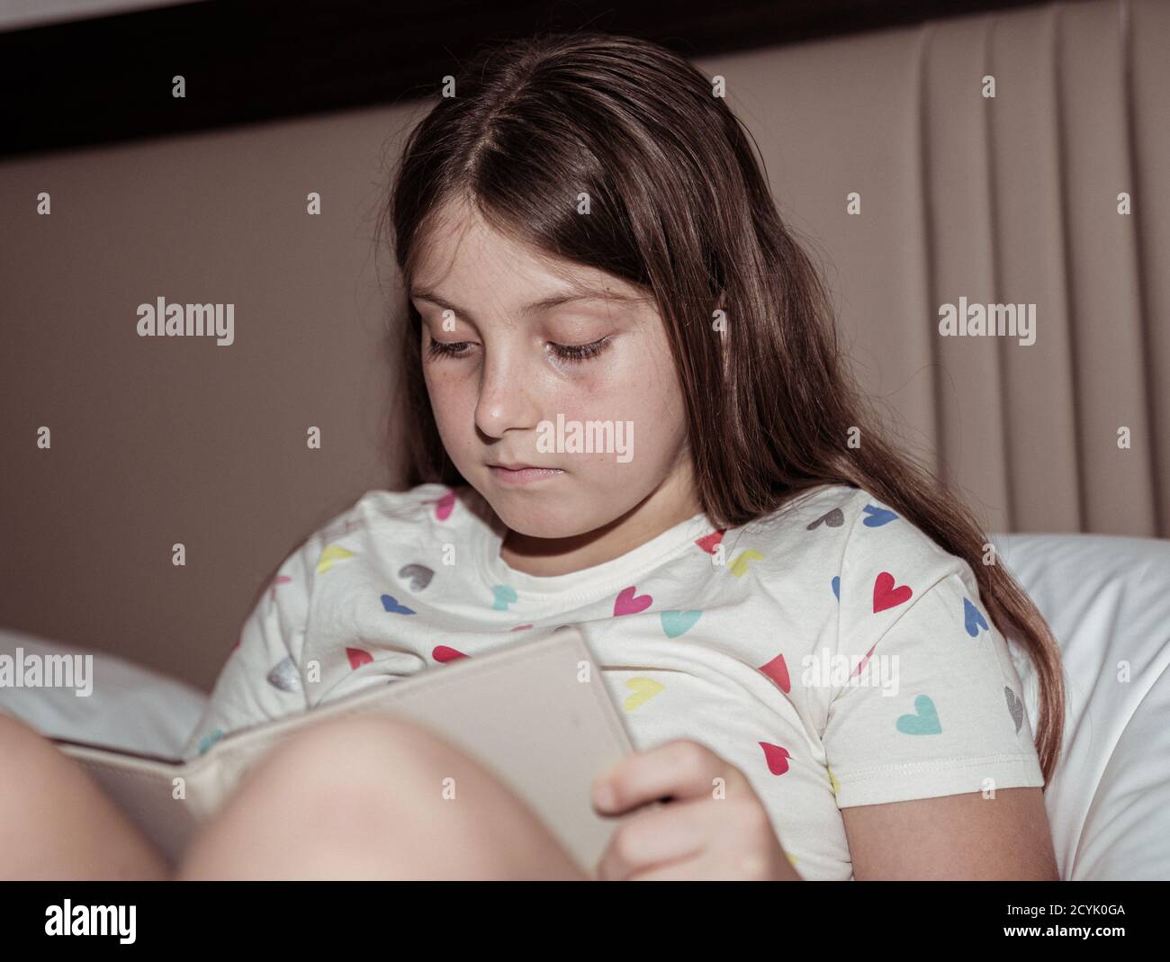 Caucasian Girl with brown hair and green eyes reading a book at night ...