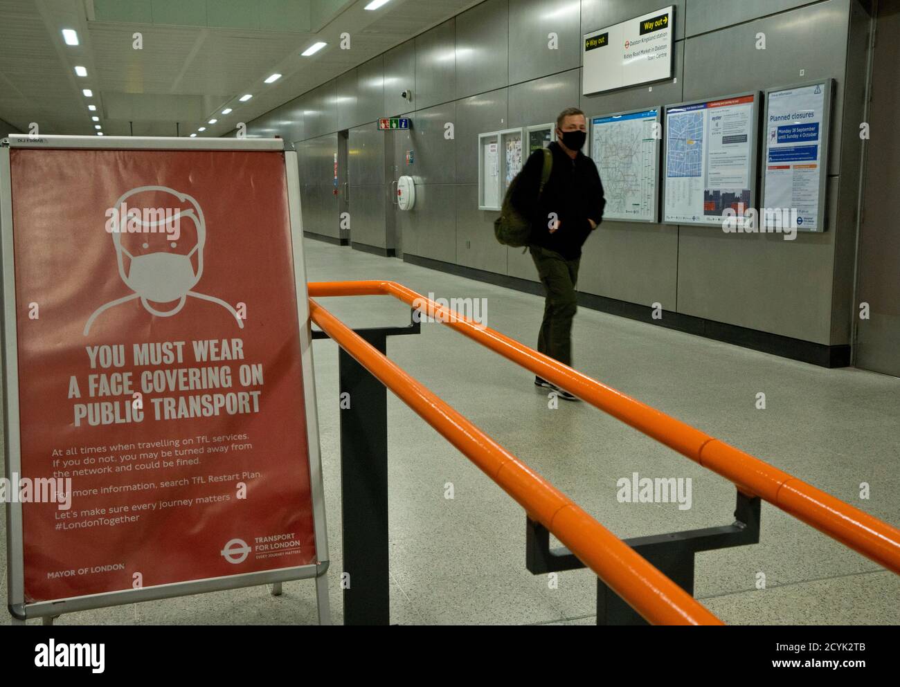 Passengers on a London Underground train station, with signs advising ...