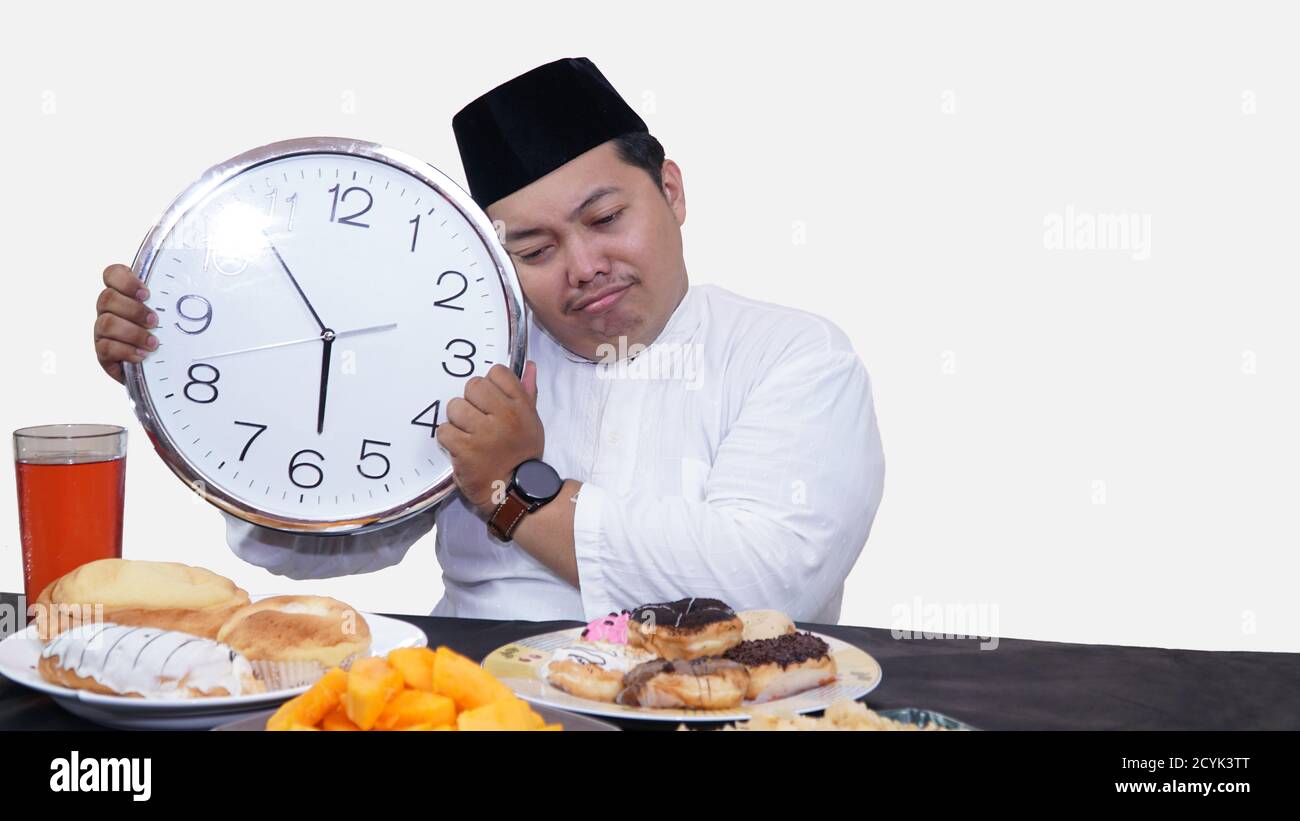 overweight man sitting and holding big round clock in front of sweet ...