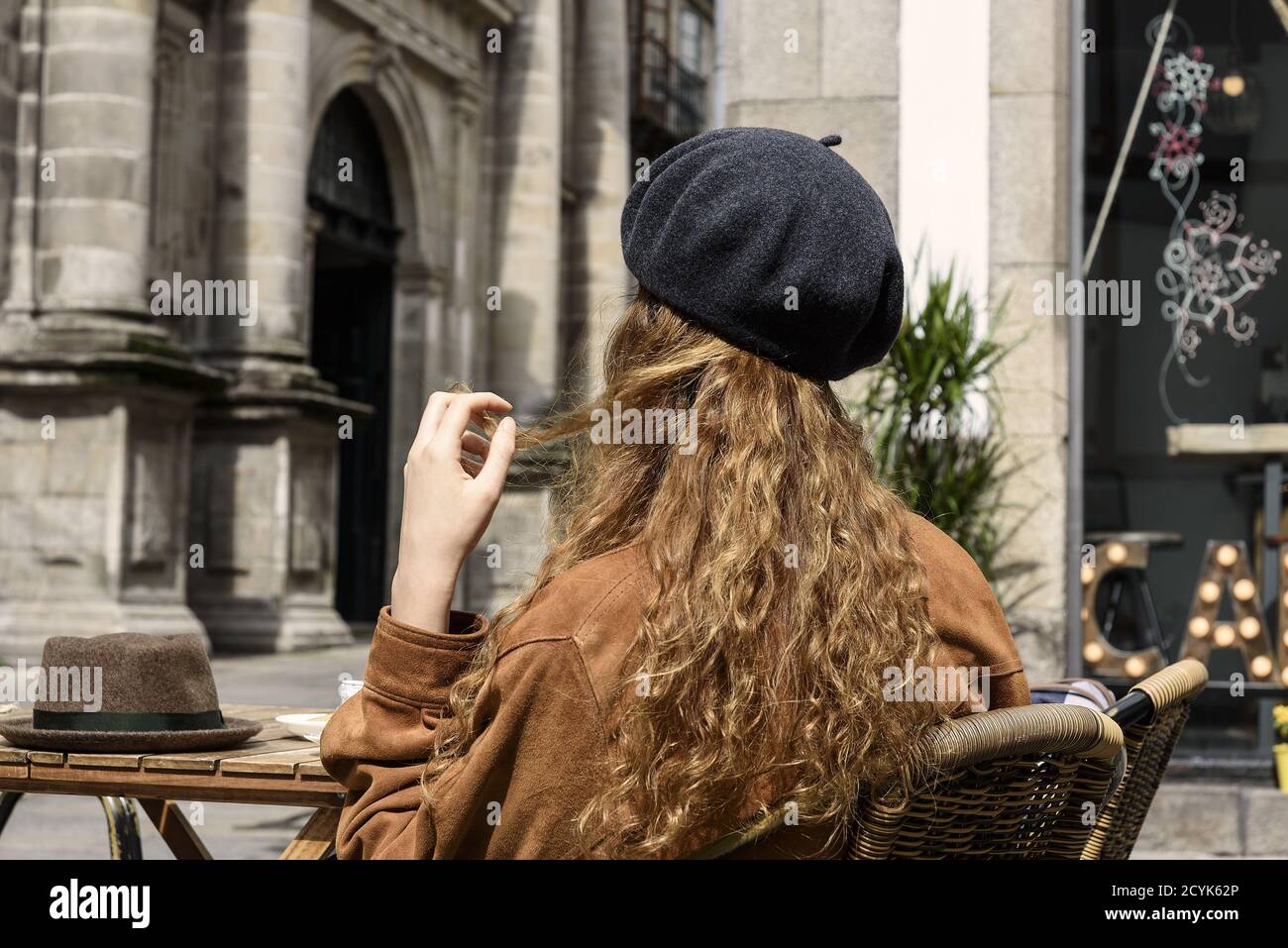 Back view of a ginger female with curly hair wearing a black beret ...