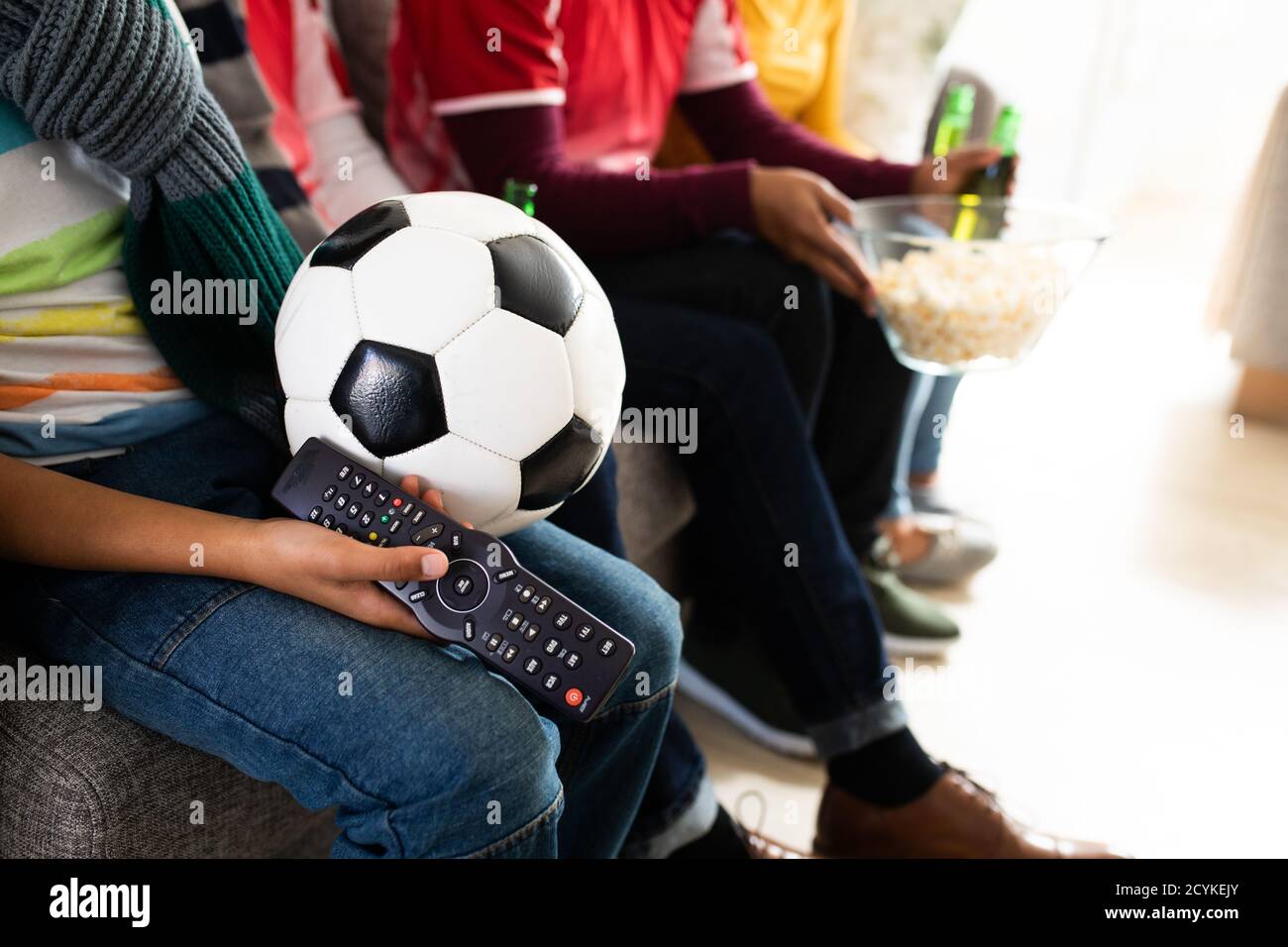 Mid section of family watching sports on TV at home Stock Photo - Alamy