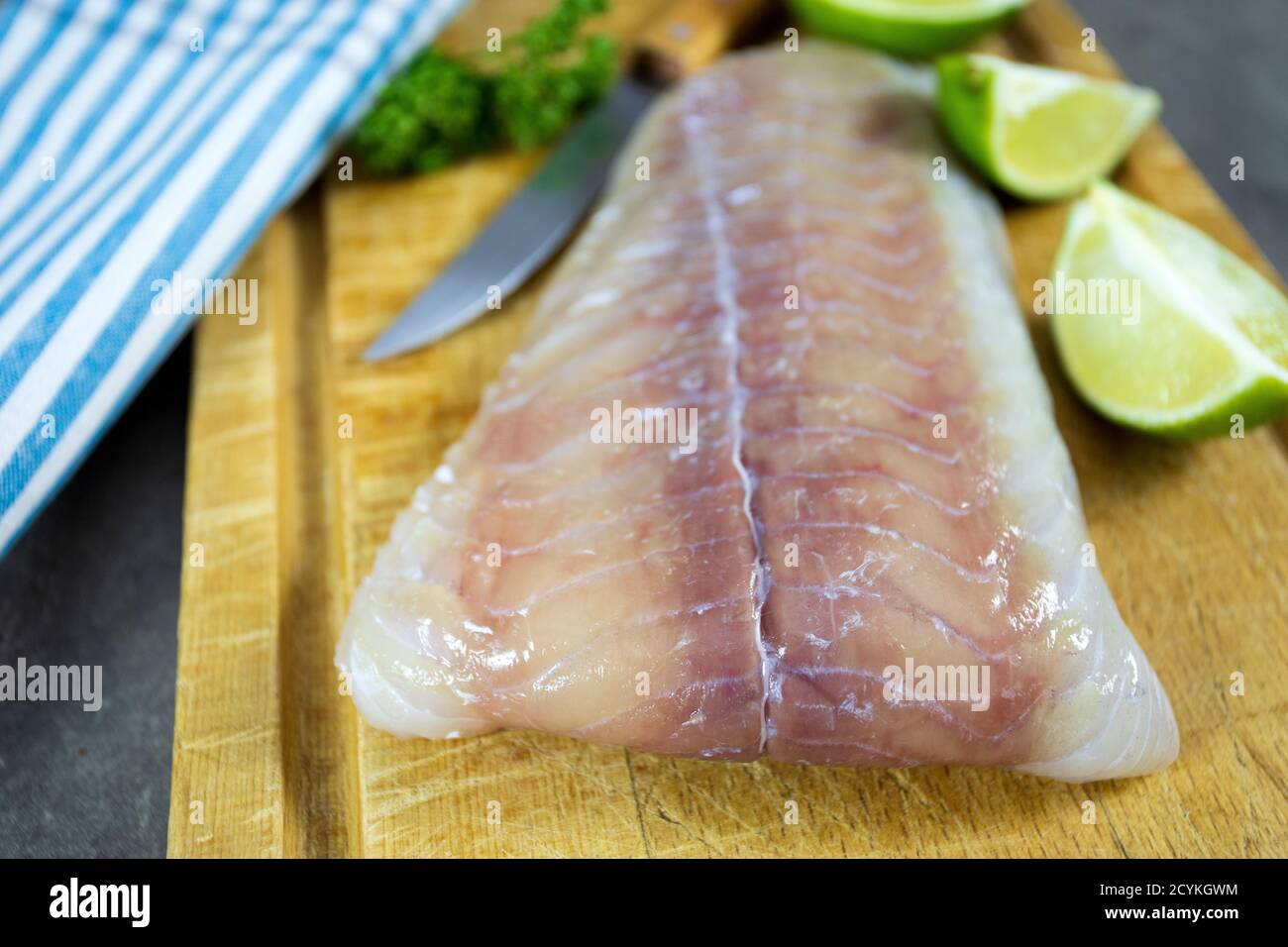 raw fish fillet (saithe) on a cutting board Stock Photo - Alamy