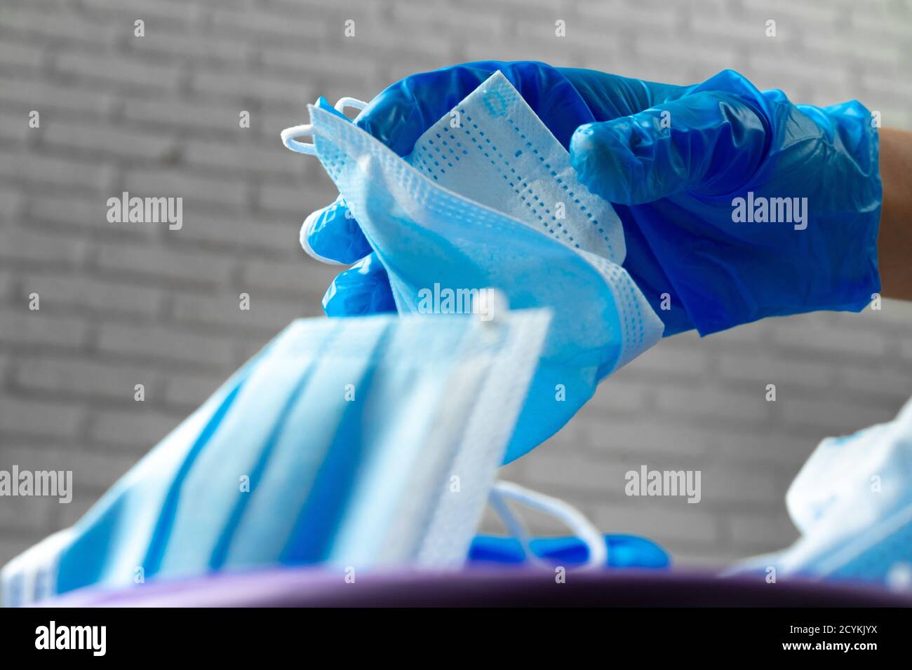 Hand putting used dirty surgical mask to a garbage bin Stock Photo - Alamy