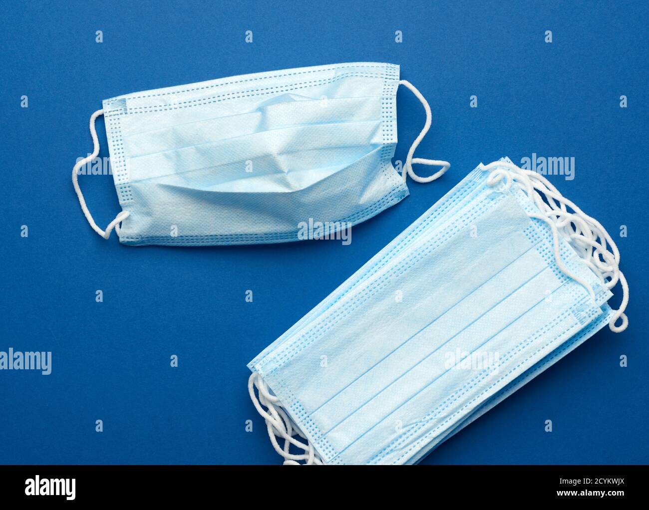 blue disposable medical mask on a blue background, personal protective ...