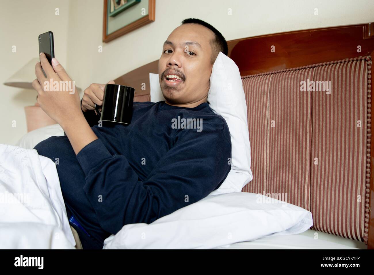 side view of Fat man has a mustache, happy with a smartphone and enjoy ...