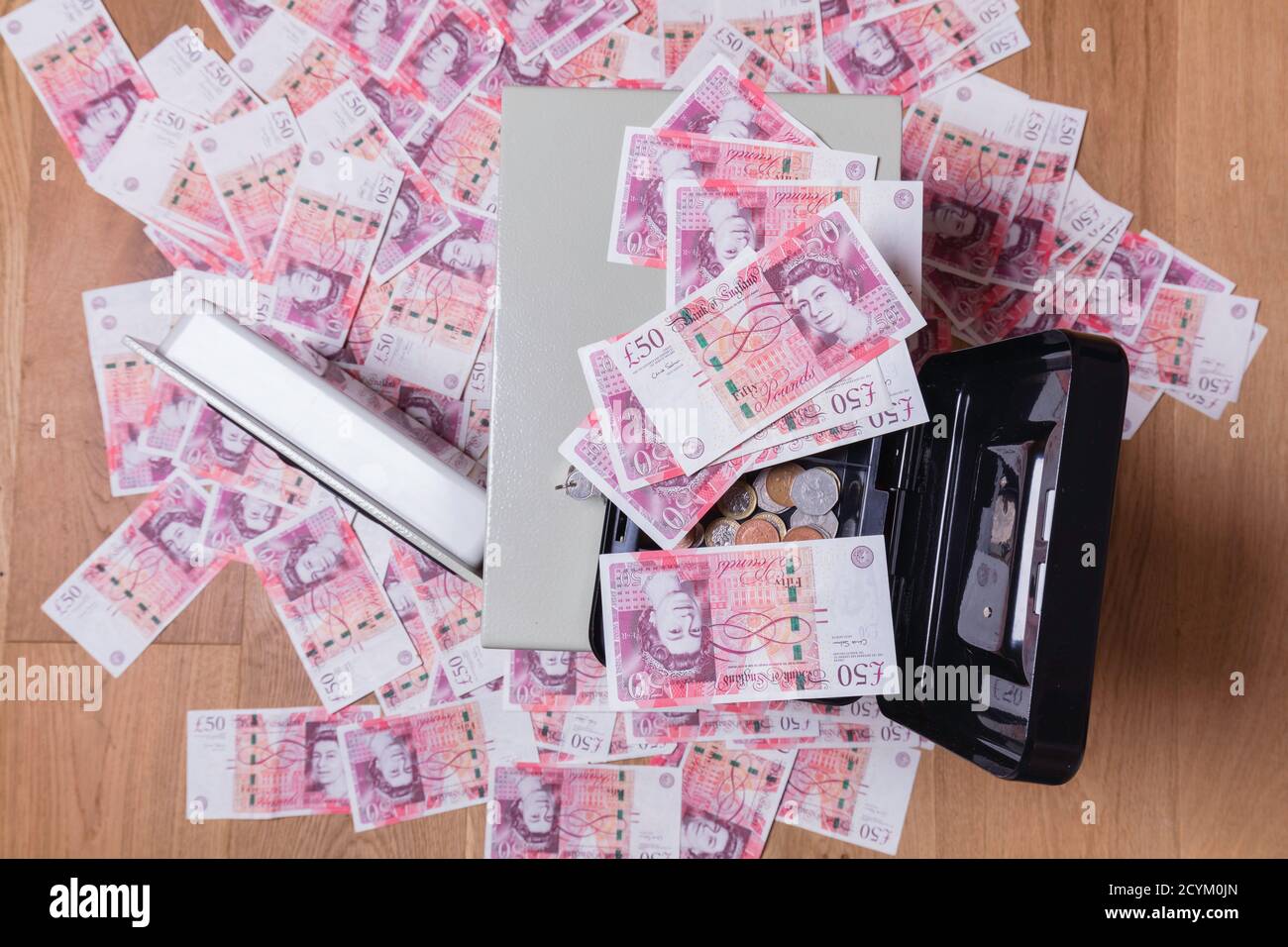 Home safe and cash box overflowing with money Stock Photo - Alamy