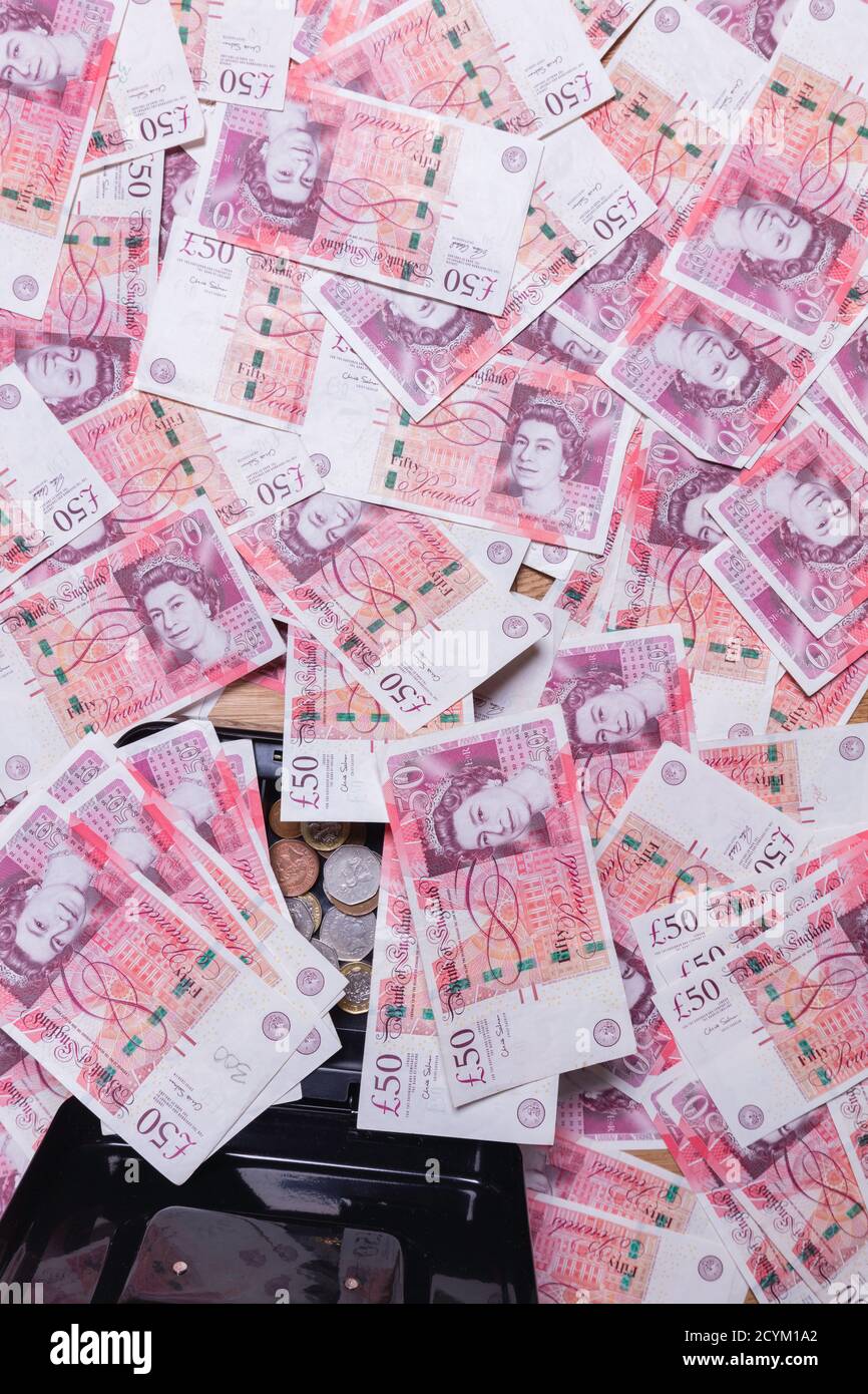 £50 banknotes overflowing from a black cash box Stock Photo - Alamy