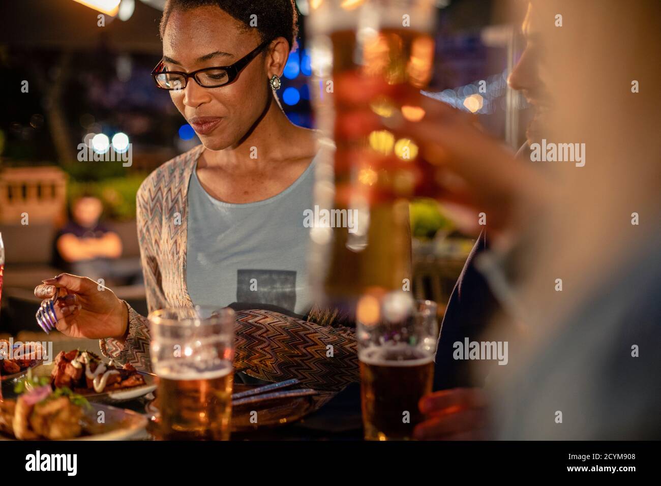 Friends drinking alcohol outdoors at a bar/restaurant, celebrating and ...