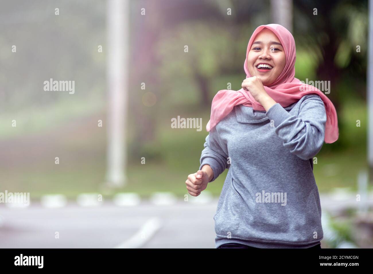 portrait of muslim young woman doing exercise and jogging outdoor at ...