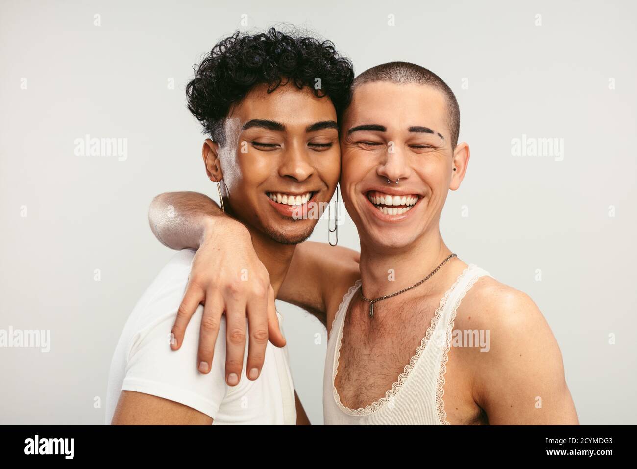 Young gay couple in love on a white background. Two young androgynous ...