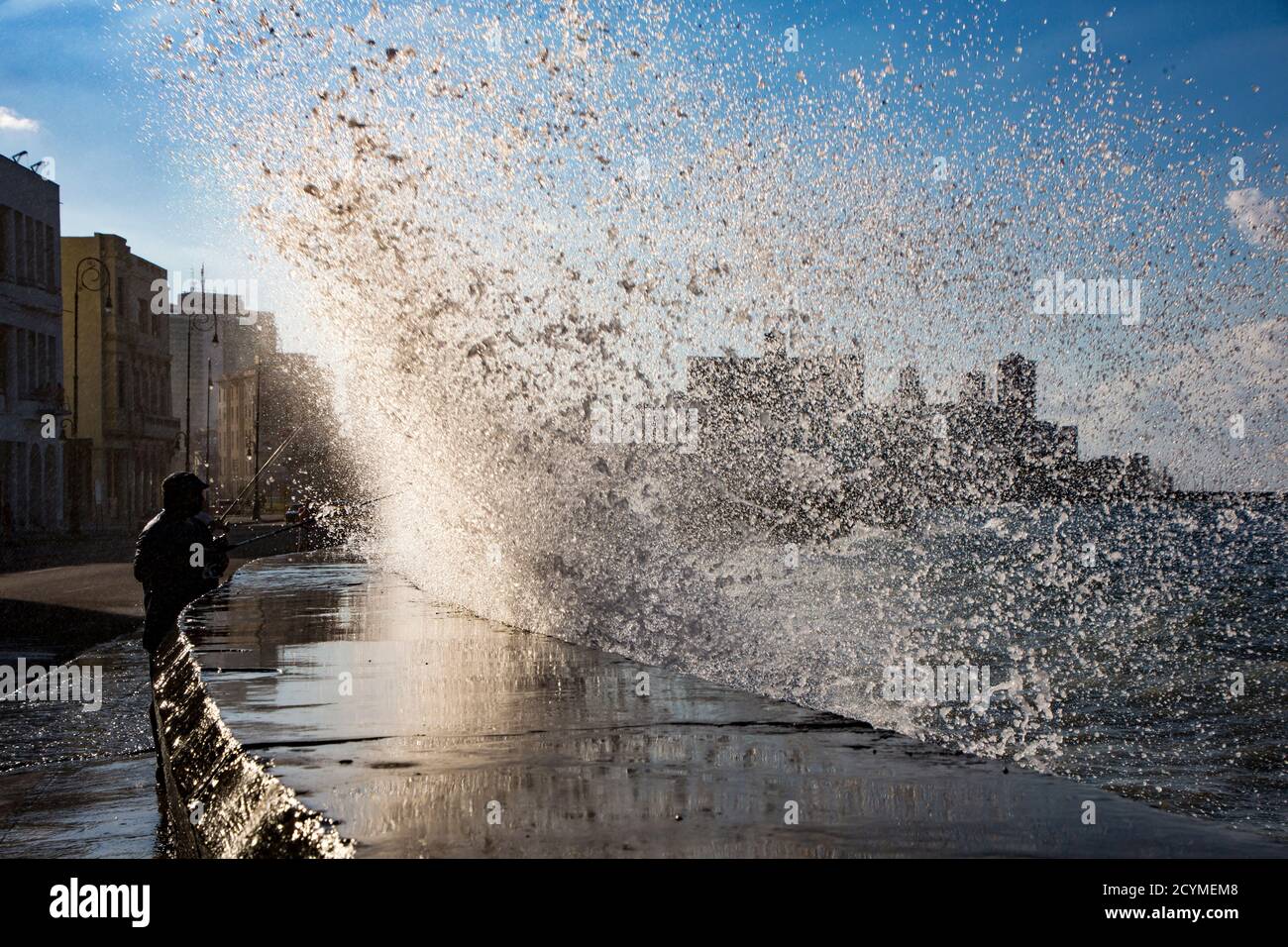 Havana, Cuba, Nov 20, 2017 - Waves crash over the Malecon wall as men ...