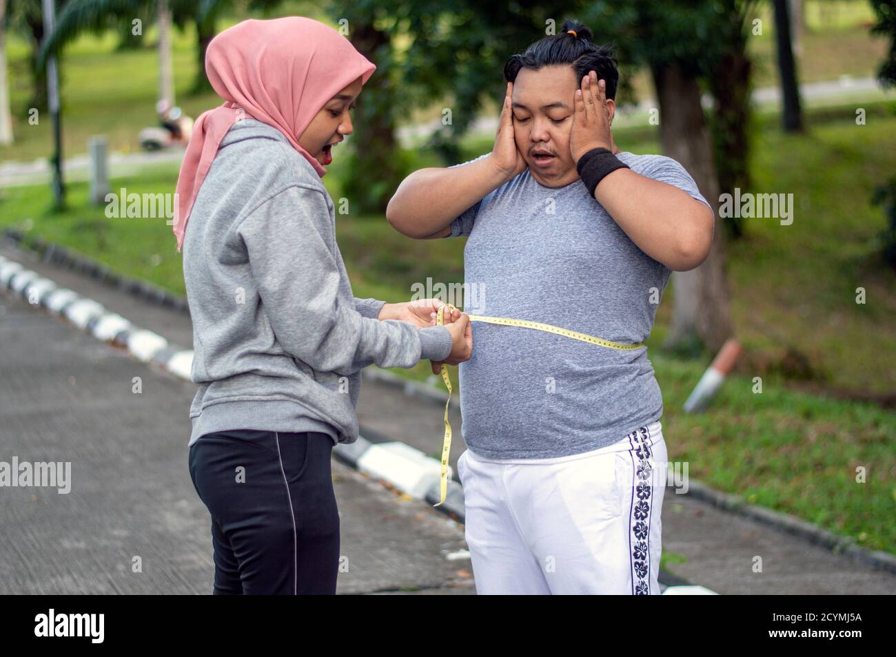 Two people, muslim woman and fat man, proportional and over weight ...