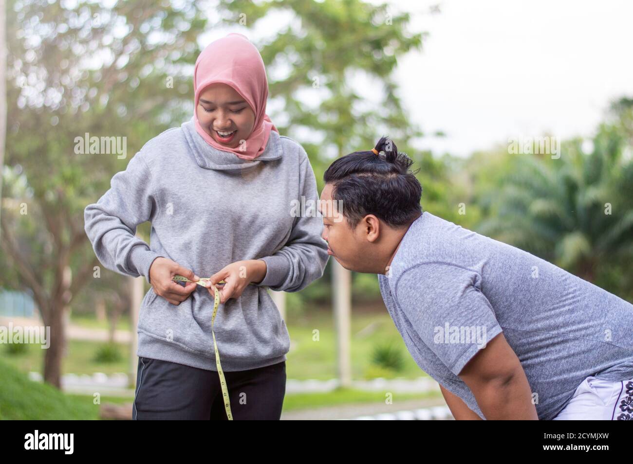 Two people, muslim woman and fat man, proportional and over weight ...