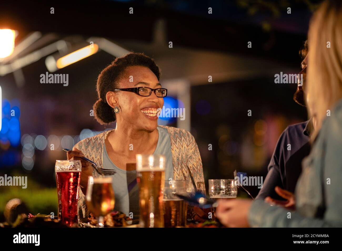 Friends drinking Alcohol outdoors at a bar/restaurant, celebrating and ...